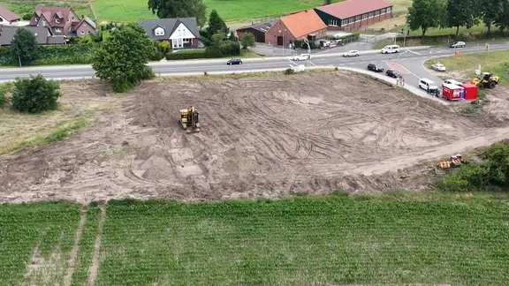Ein Bagger steht auf einem Baugebiet, in welchem ein Blindgänger entdeckt wurde.